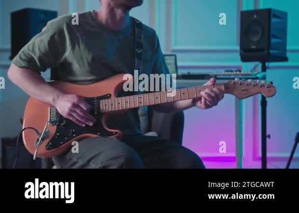 Man plays guitar in professional music studio. Man plays a musical ...