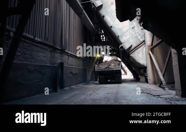 Large dump truck hauls construction debris down a dirt road from an old ...