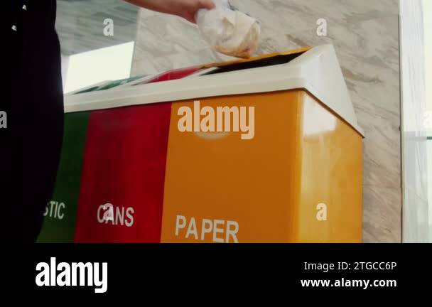 Woman throws garbage into a trash can. Plastic bag in the trash can ...