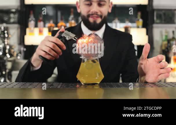 Professional bartender wearing stylish black suit using gas burner to ...