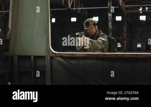 American soldier in safety helmet and uniform aiming through rifle ...