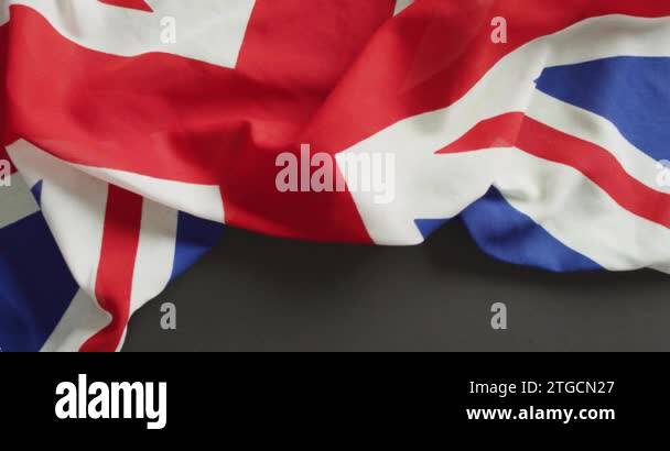 Video of creased flag of great britain lying on white background ...
