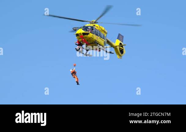 A person is pulled up from a hovering ADAC rescue helicopter in front ...