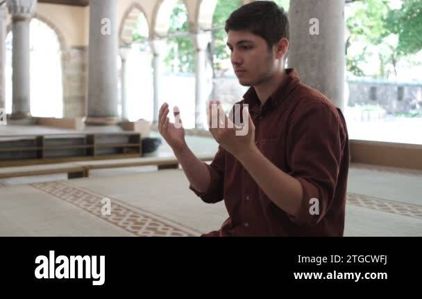 Image of young man praying with his hands raised to the sky, young man ...