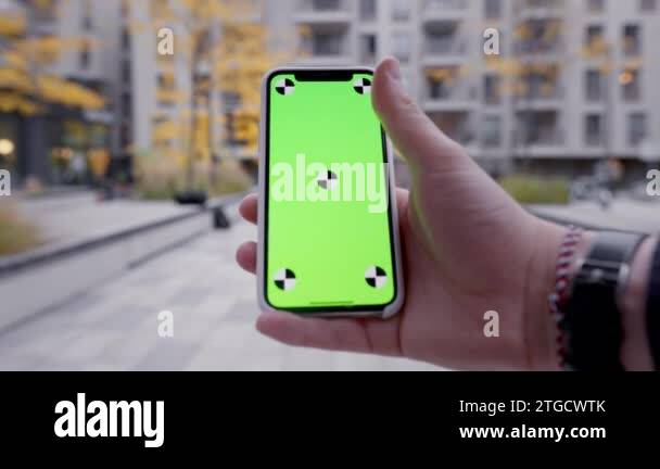 Cropped view of the man holding phone with green screen smartphone ...