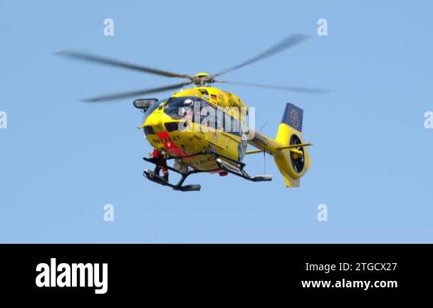Hovering rescue helicopter in front of blue sky. German ADAC air ...