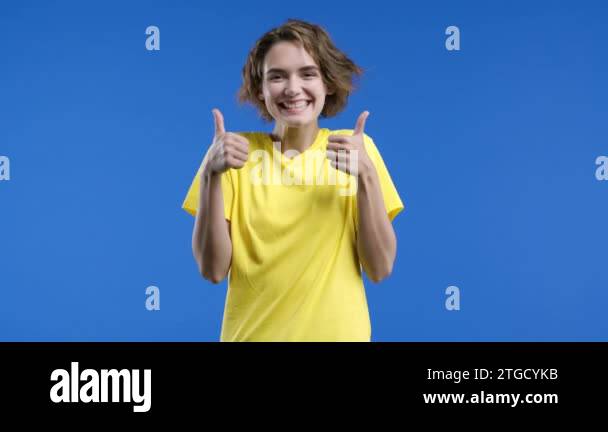 Pretty woman makes hand sign like, thumbs up gesture. Happy girl ...