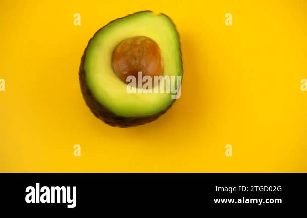 Rotating segment of a ripe and juicy avocado on an orange background ...