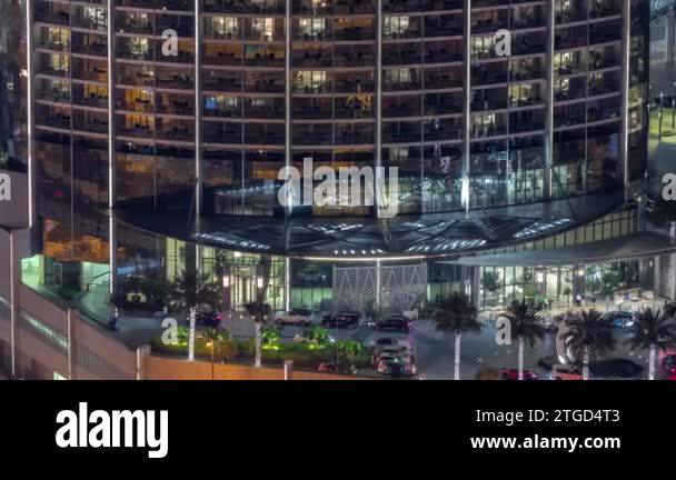 Illuminated panoramic windows in apartments of a high class building at ...