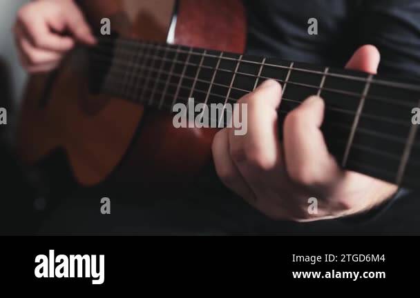 Hands playing guitar, holding fretboard and touch strings with fingers ...