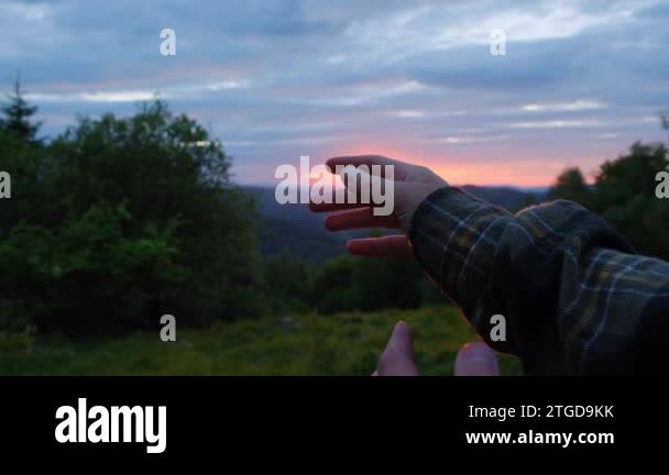 Back view of couple holding hands and caressing each other fingers on sunset filled beautiful ...