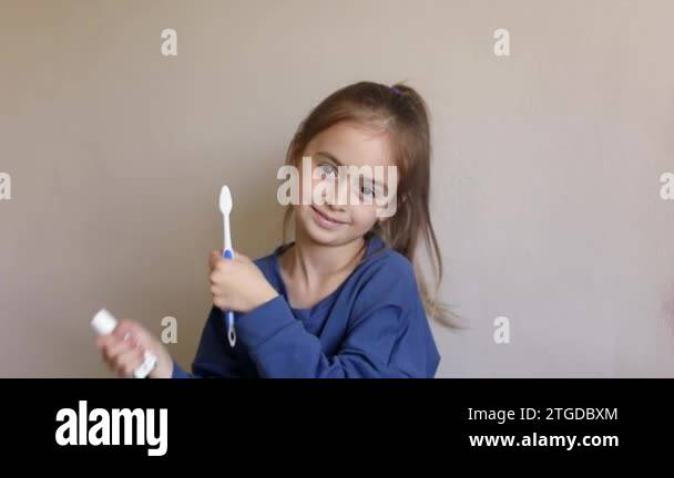 Cute little girl brush her teeth in the bathroom. Girl weight ate ...