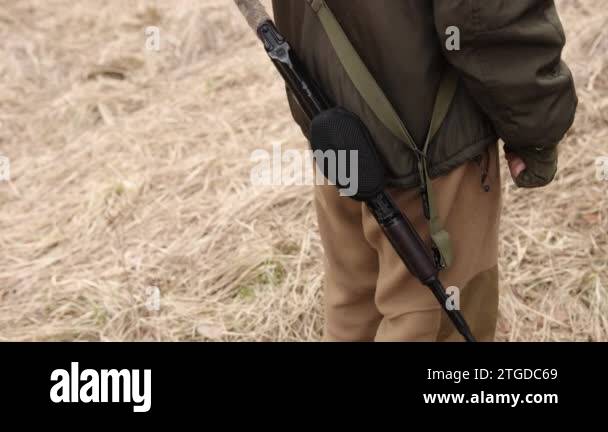 Man holds machine gun behind back. Secret agent with rifle. Male ...