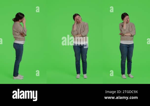 Female model in pain suffering from headache over greenscreen backdrop ...