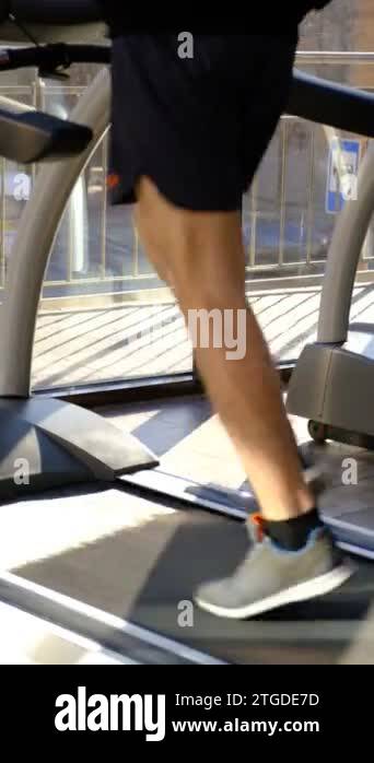 Men's legs on a treadmill, a man jumps on a rope. Fast leg movements on ...