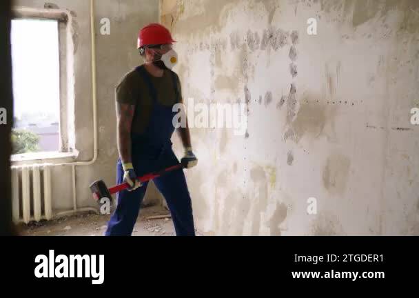 Contractor wrecks concrete wall with sledgehammer for rearrangement ...