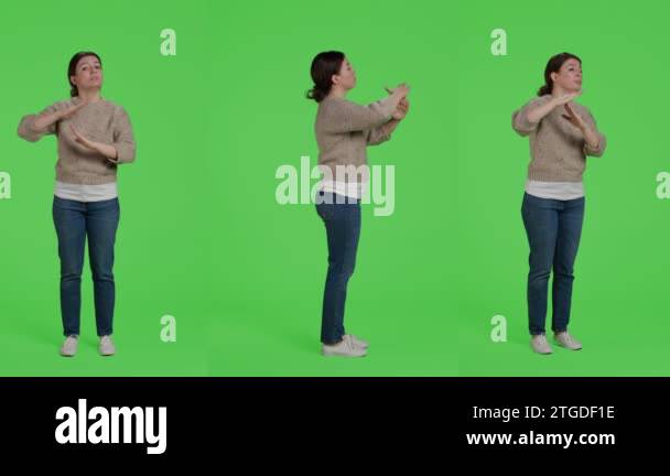 Full body of model doing t shape timout sign on green screen backdrop ...