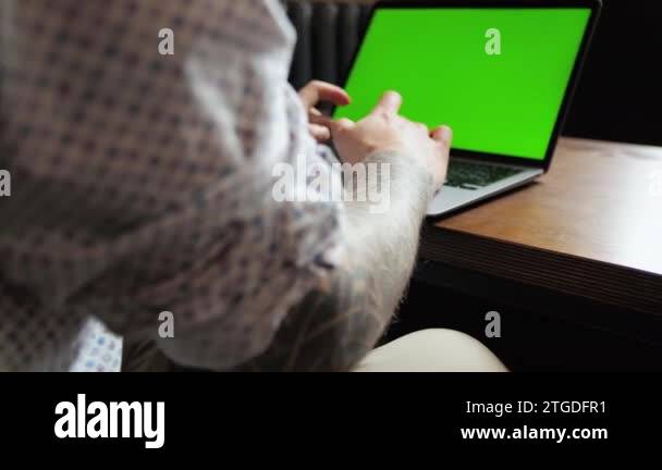A young man freelance businessman brunette sits in a cafe behind a ...