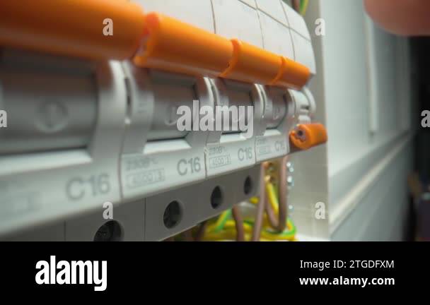 Finger turning on high voltage electrical switches in switchboard ...