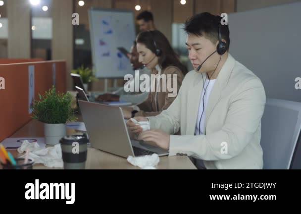 Unhealthy asian male employee suffering from seasonal allergy and runny ...