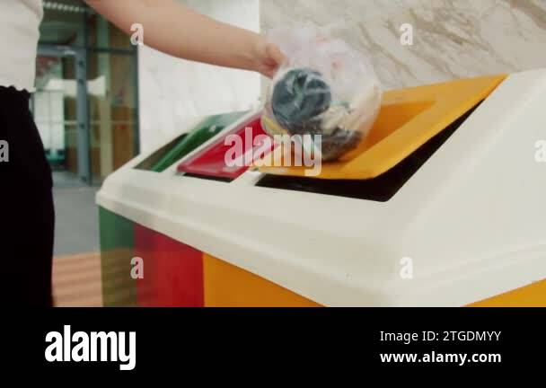 Woman throws garbage into a trash can. Plastic bag in the trash can ...