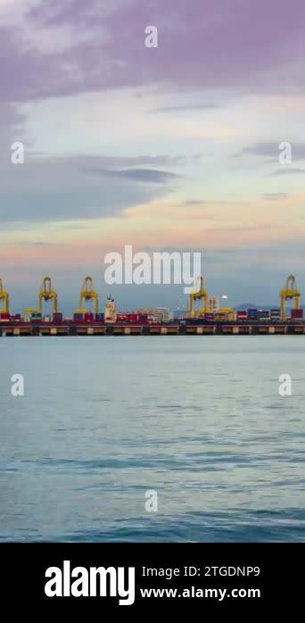 vertical timelapse of deep sea port with cargoship loading and ...