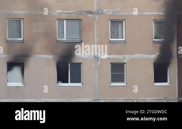 Black smoke billows from three windows of an apartment building. Fire ...