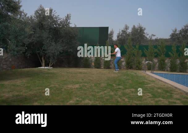 Man jumps high hitting frisbee with head launched by friend. Men have ...