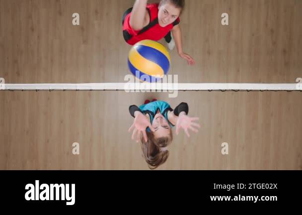 Two young female athletes playing volleyball on the playground. Top ...