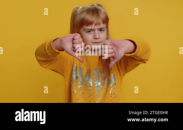 Dislike. Upset young preteen child girl kid showing thumbs down sign ...