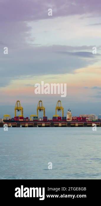 vertical timelapse of deep sea port with cargoship loading and ...