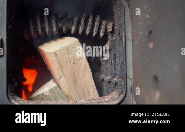 The fire flares up in the furnace of a wood-burning boiler filled with ...