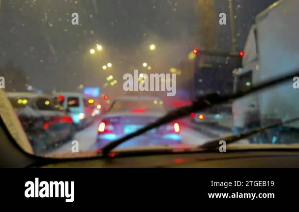 Night city traffic, epic snow storm in winter city, falling snow ...