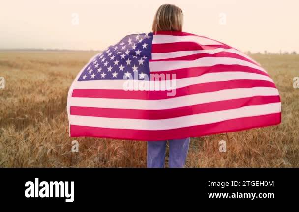 Back view of patriotic happy woman with USA flag who stays in the ...