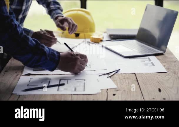 Engineers and architects discuss construction plans. Work on the blueprints on the desk in the ...