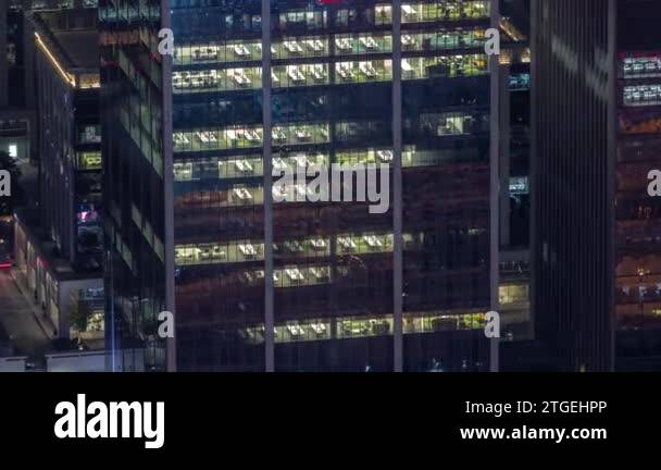 Illuminated panoramic windows in offices of a high class building at ...