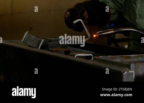 Close-up of a welder welds parts using a semi-automatic welding machine ...