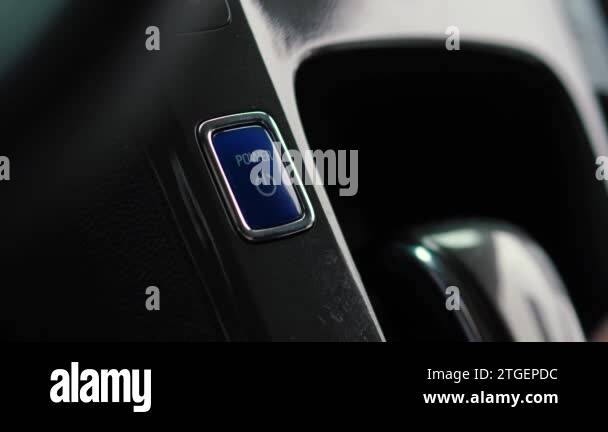 Start keyless ignition hybrid car electric engine. Finger pushing Blue ...