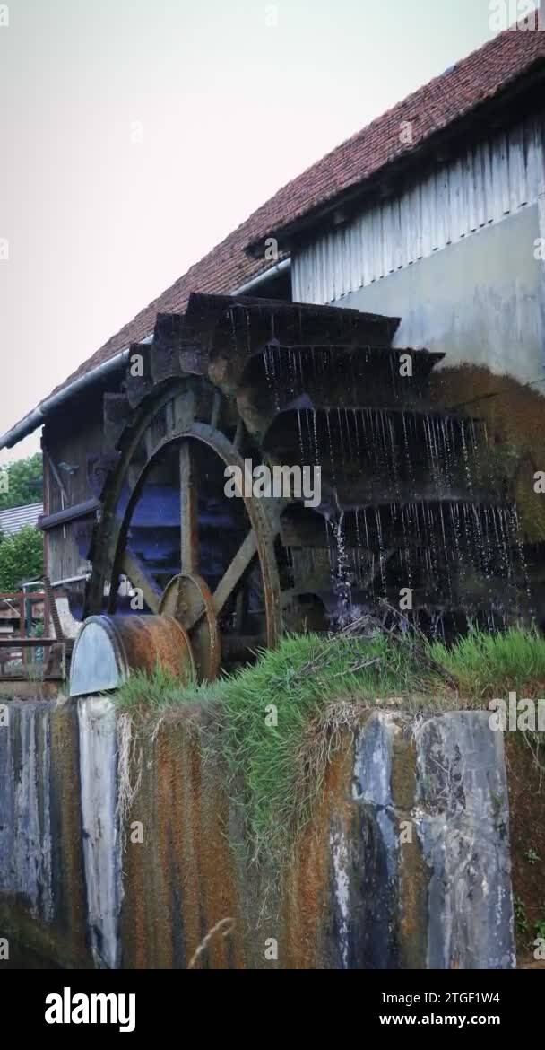 Wheel of old water mill. Wooden wheel spinning under stream of water ...