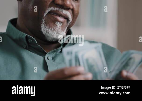 Close-up unrecognizable old African gray bearded man holding money ...