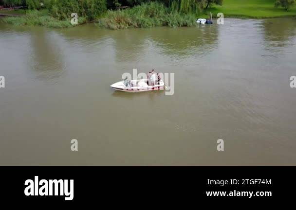 A 4K aerial of a boat full of people sailing on Modder River in ...