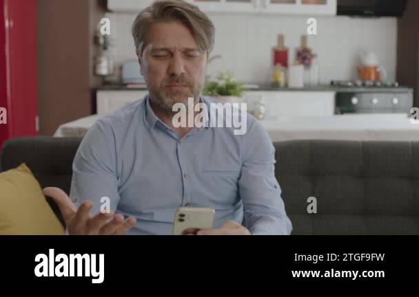 Unhappy man feels uncomfortable while using smartphone.Angry man having ...