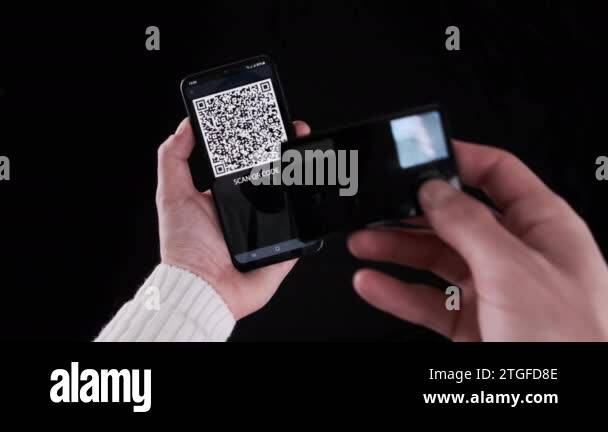 Young man uses portable cold crypto wallet to scan QR code on a ...