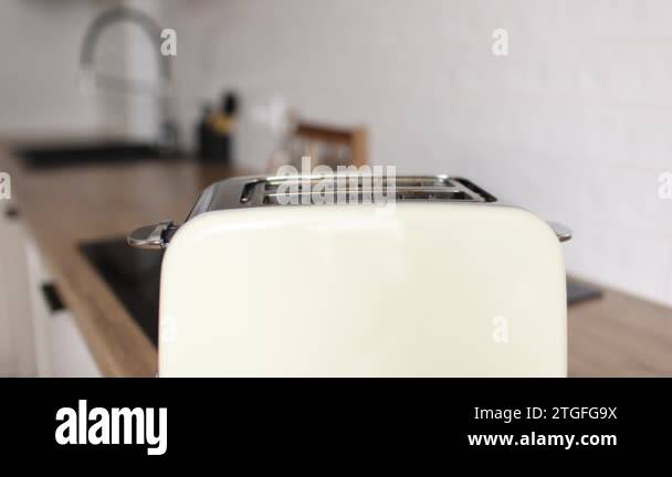 close up of hand are puting toasts bread in toaster in the kitchen ...