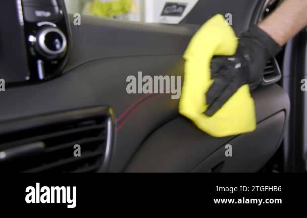 Male hands in gloves clean the car with a yellow rag, polish the ...