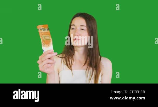 young girl, holding euro money in her hands in front of her, looks at ...