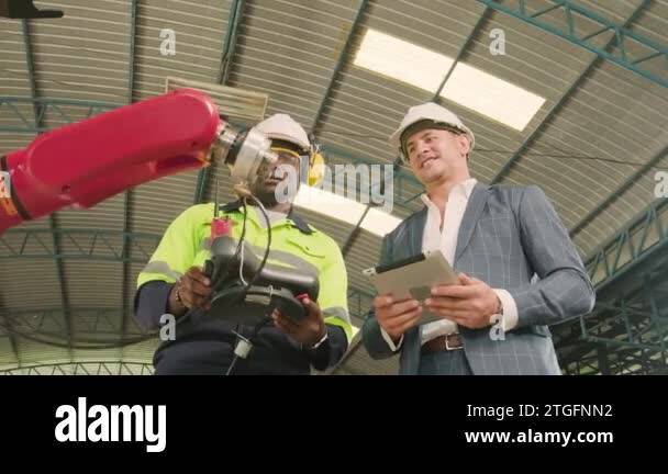 An African American engineer demonstrates smart robotic arm control to ...