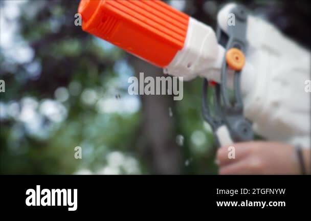 Water gun spraying water close up outside. Plastic Toy Weapon splashing ...