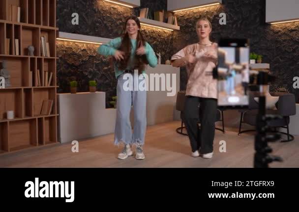 Two pretty girls filming their rhythmic synchronized dance moves. Young ...