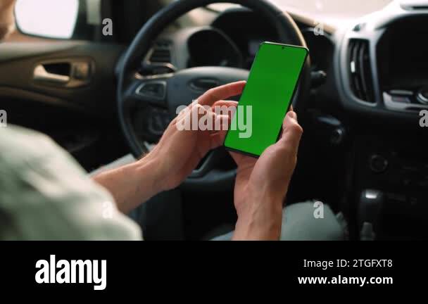 Male driver using a smartphone inside the car. Chromakey smartphone ...